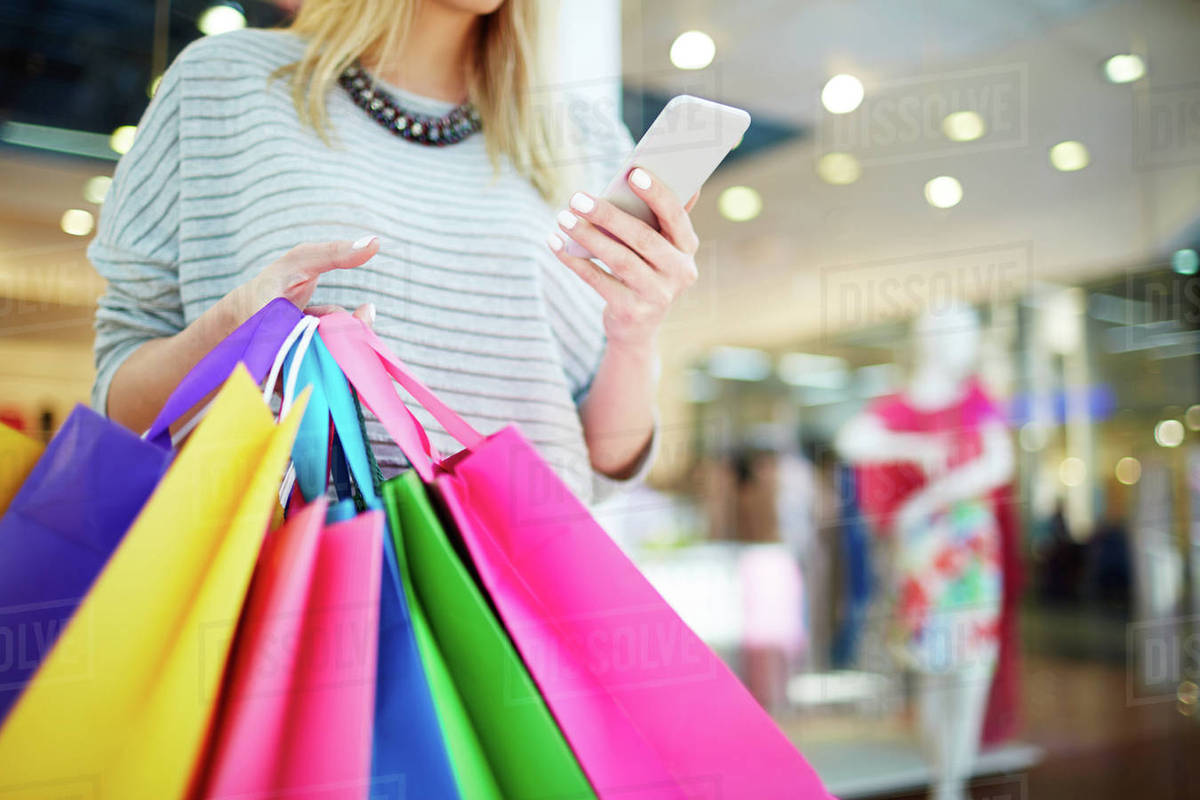 Young shopper reading or writing sms in shopping mall - Stock Photo ...