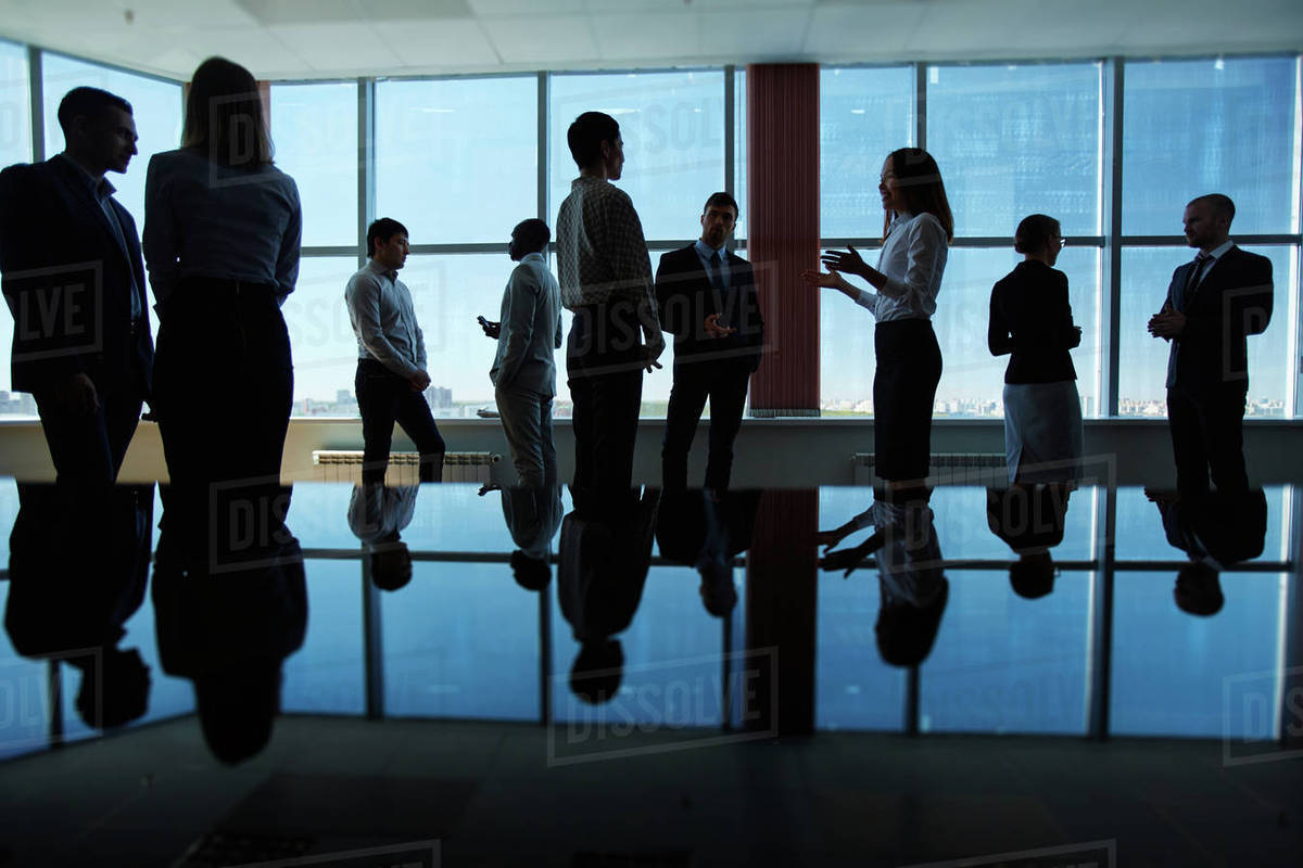 Modern business people interacting by window - Stock Photo - Dissolve