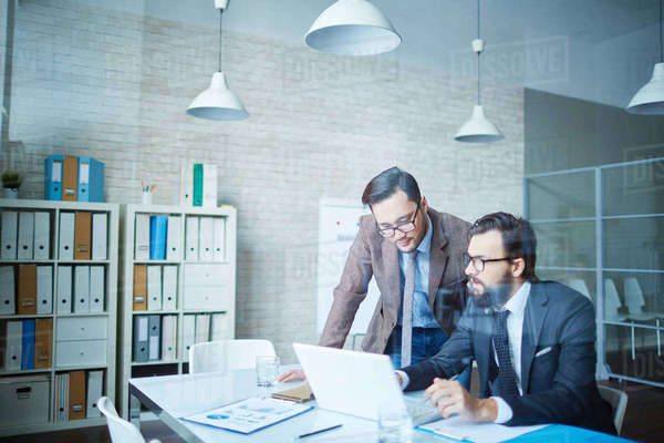 Two male colleagues talking to the business point - Stock Photo - Dissolve