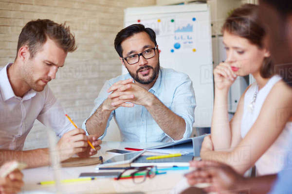 Businessman explaining something to colleagues - Stock Photo - Dissolve