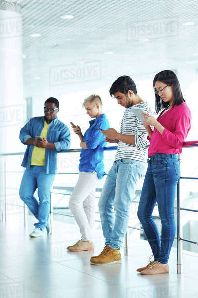 Modern students with gadgets standing in row - Royalty-free Stock Photo ...