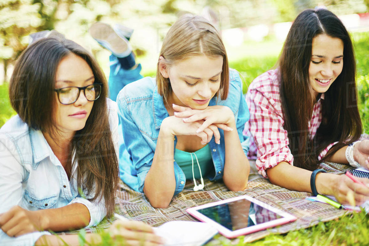 Modern college students reading outdoors - Royalty-free Stock Photo ...