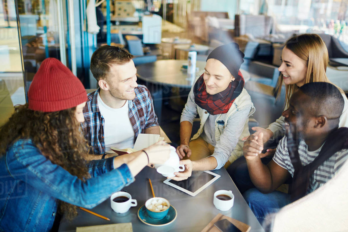 Group of friends sitting at cafe and drinking coffee - Royalty-free ...