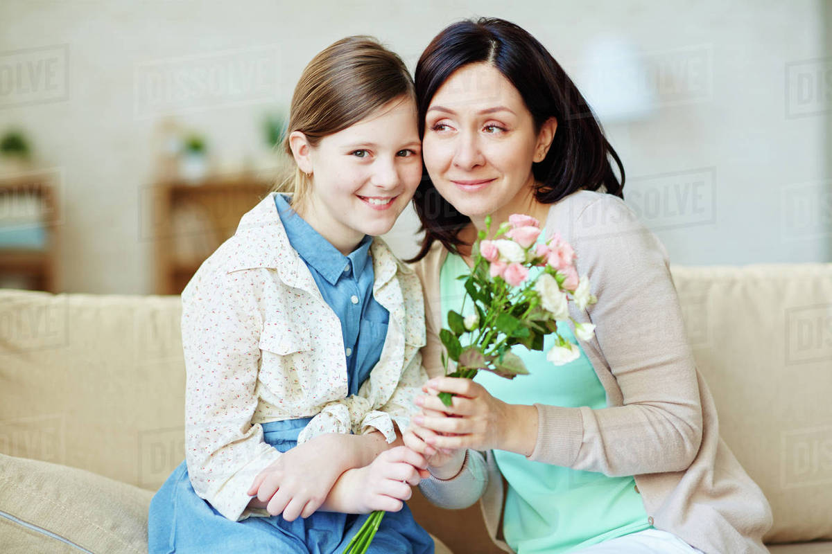 Young girl giving roses to her mom - Stock Photo - Dissolve