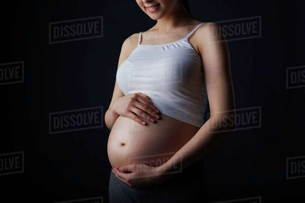 Low-key of young pregnant woman belly - Royalty-free Stock Photo | Dissolve