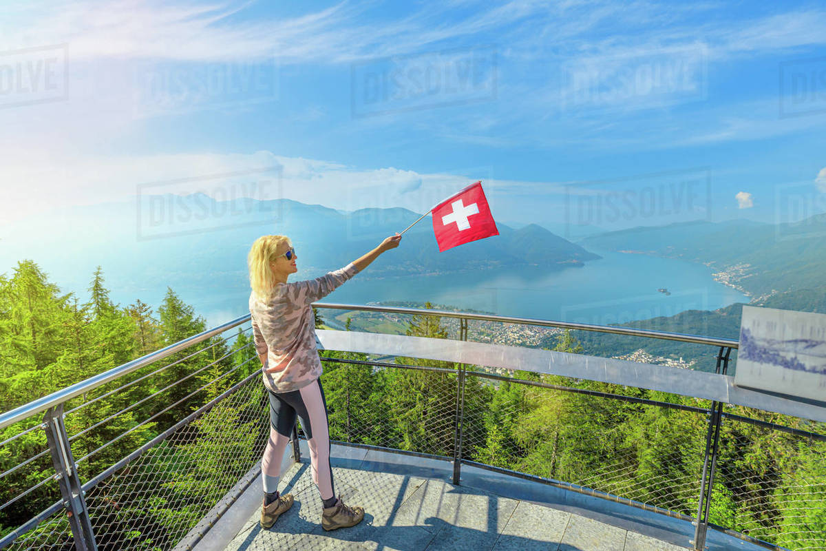 Woman with Swiss flag on Cardada-Cimetta mount overlook in Switzerland ...