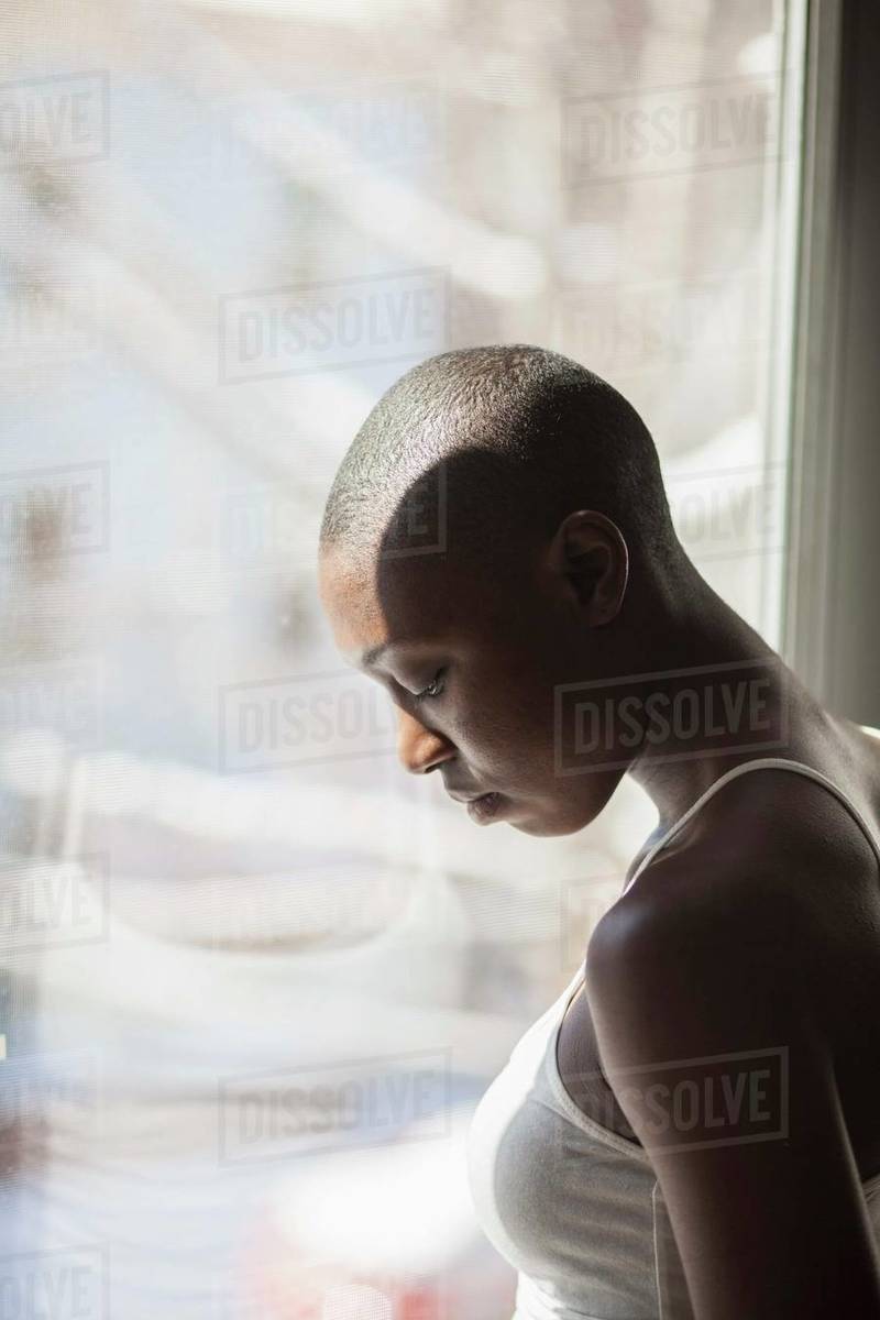 Young woman gazing thoughtfully out a window - Royalty-free Stock Photo ...