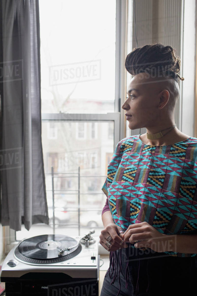 A young woman by a record player - Stock Photo - Dissolve