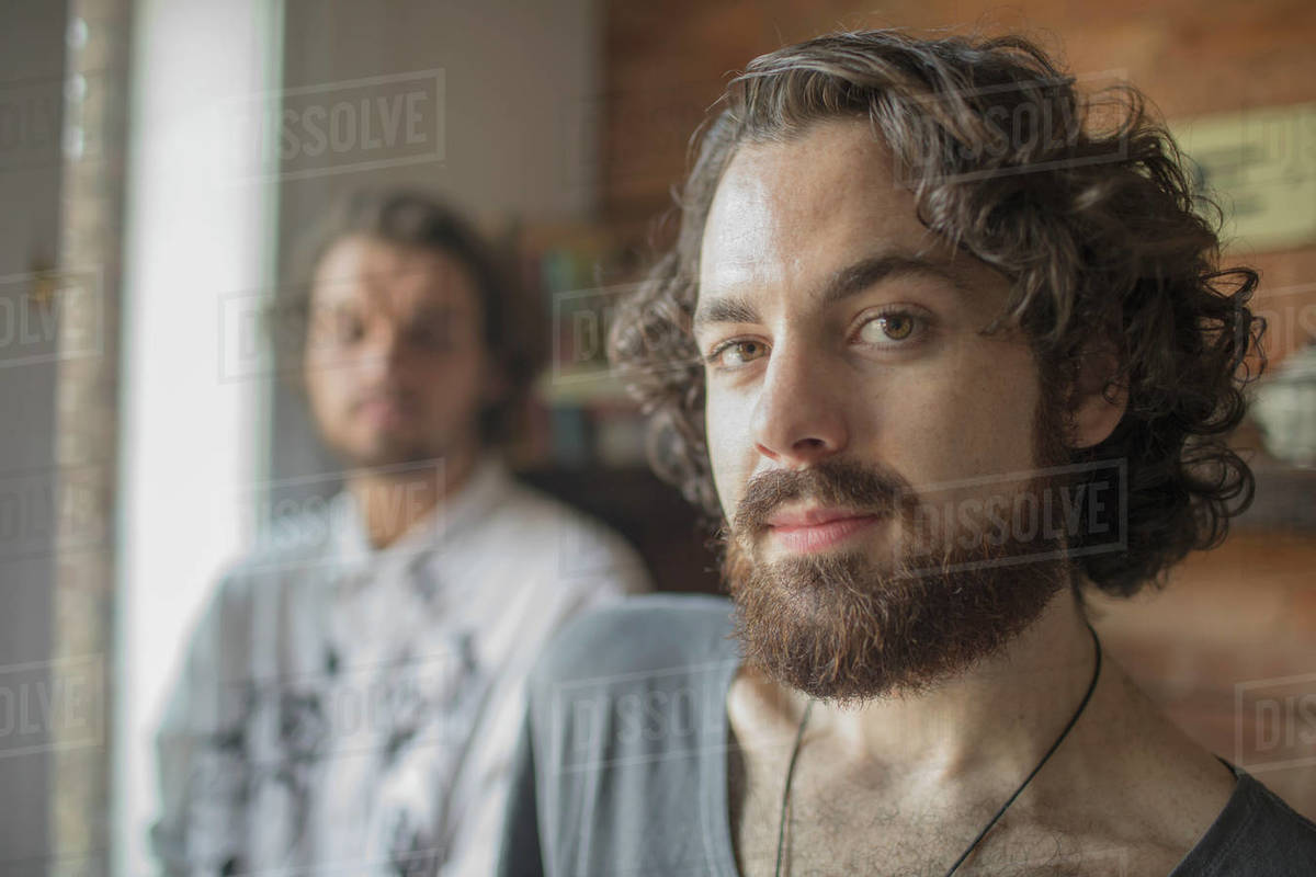 Portrait of a young man with his boyfriend in the background - Royalty ...