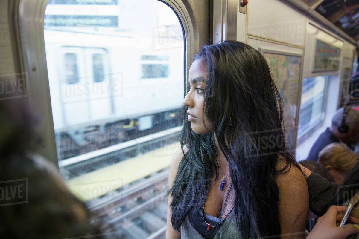 Young woman looking out the window of a train in Queens, New York ...