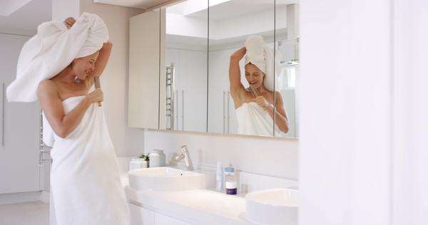 Beautiful woman singing in bathroom wearing white towel dancing in ...