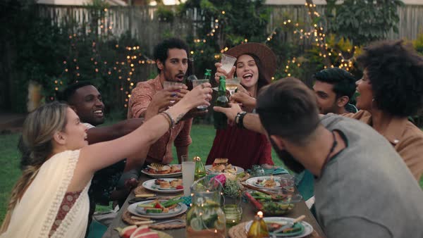 Fun group of friends making toast celebrating friendship at dinner ...
