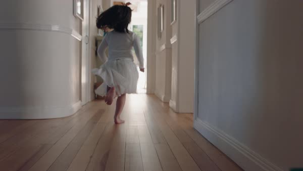 Happy little girl running throughout house wearing tutu excited to play ...