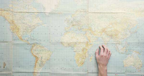 Top view hands pointing at vintage world map connecting global markets ...