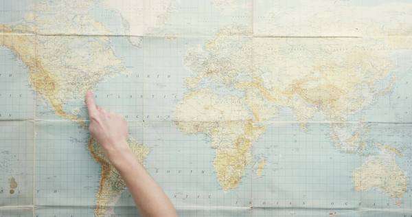 Top view hands pointing at vintage world map connecting global markets ...