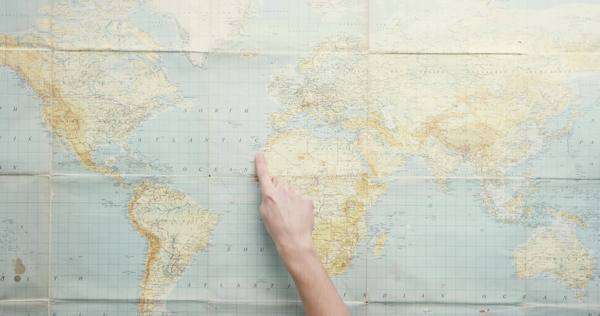 Top view hands pointing at vintage world map connecting global markets ...