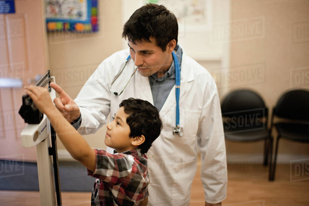 Doctor measuring young patient's weight on medical scales. - Royalty ...