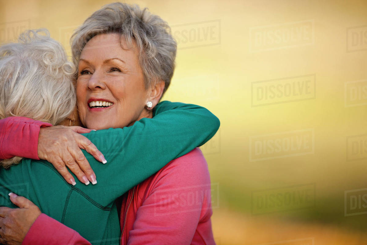 Smiling senior woman hugging her friend. - Stock Photo - Dissolve
