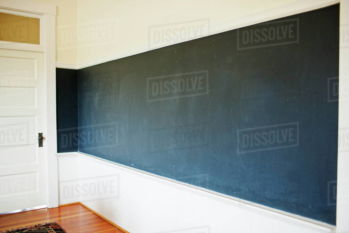 Empty chalkboard covering the wall of a classroom. - Stock Photo - Dissolve