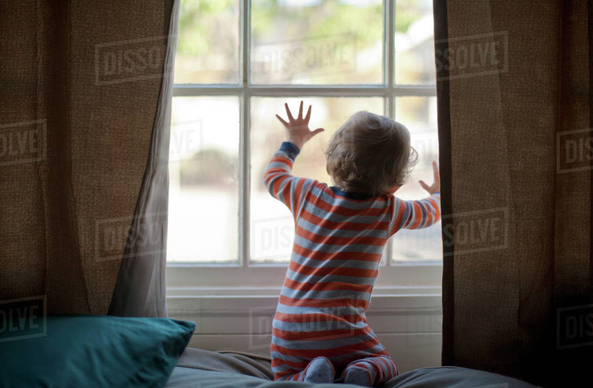 Baby girl pressing her face against a window plane. - Stock Photo ...