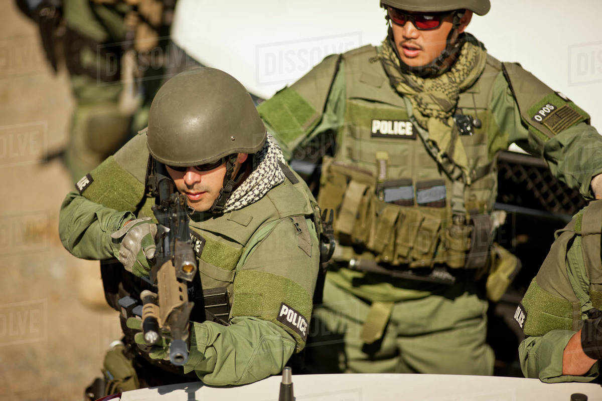 Male police officer aiming a gun toward a target during an exercise at ...