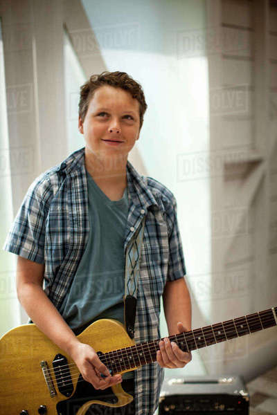 Teenage boy playing n electric guitar in a garage. - Royalty-free Stock ...