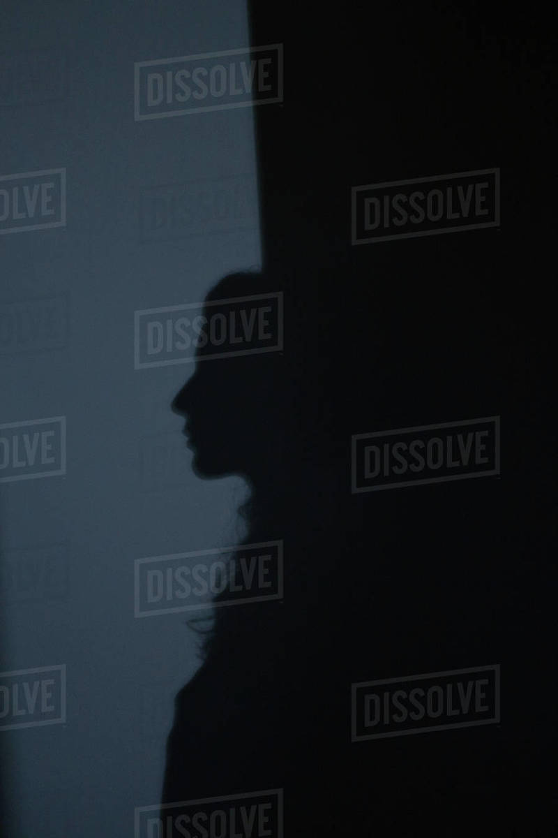 Shadow of a woman on wall at night - Royalty-free Stock Photo | Dissolve