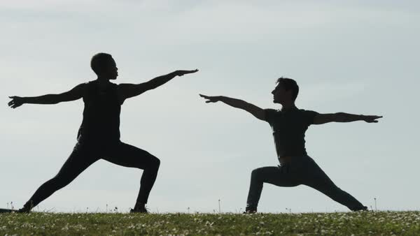 Silhouettes of two people finishing their yoga poses outdoors - 4K ...