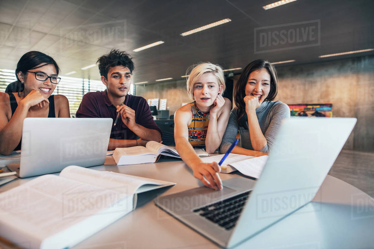 College students using laptop while sitting at table. Group study for ...