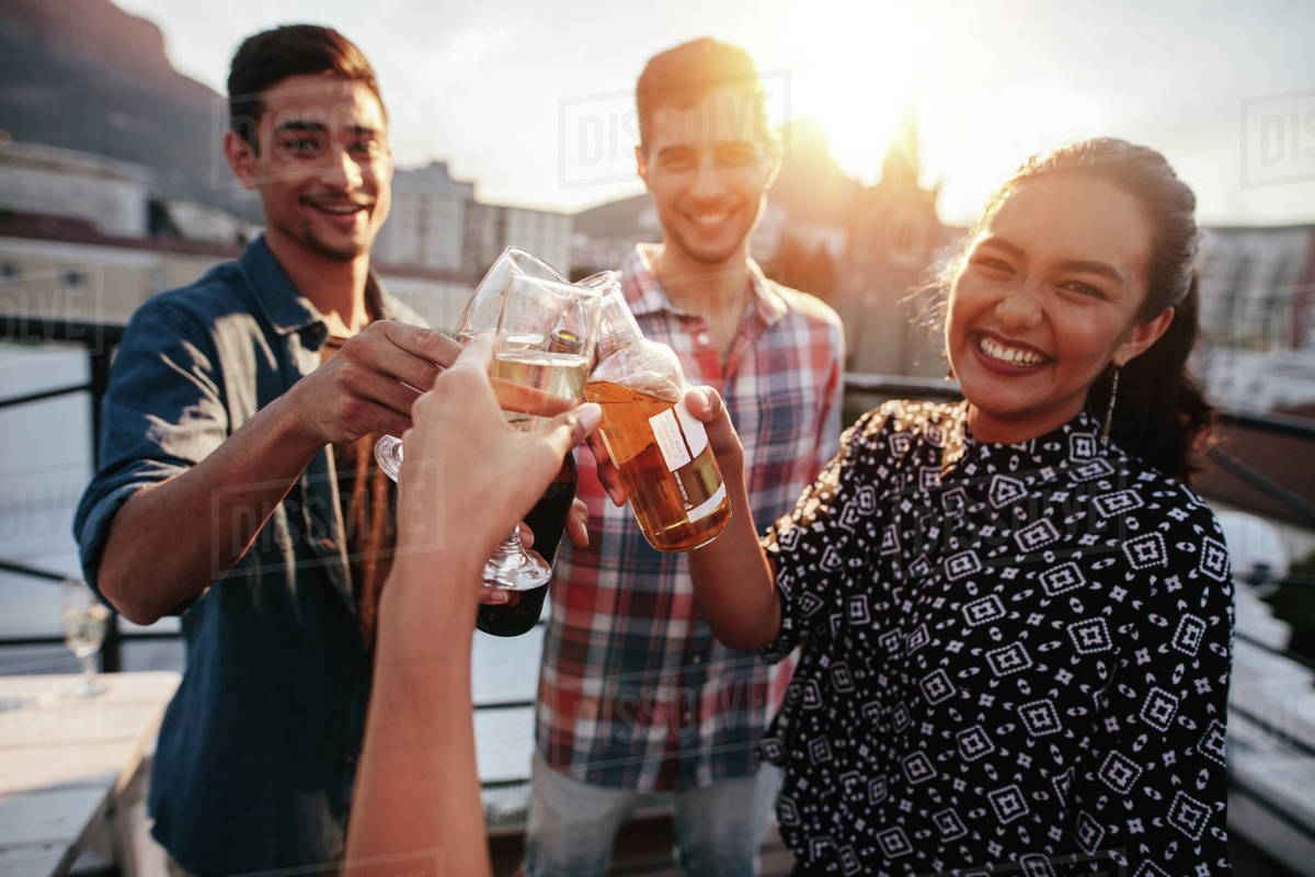 Young friends hanging out and enjoying drinks on rooftop. Young people ...