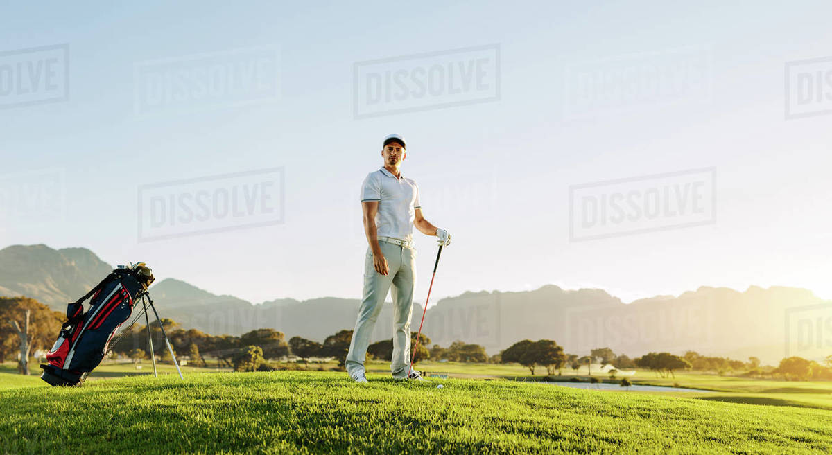 Full length of young caucasian man standing on golf course on a summer ...