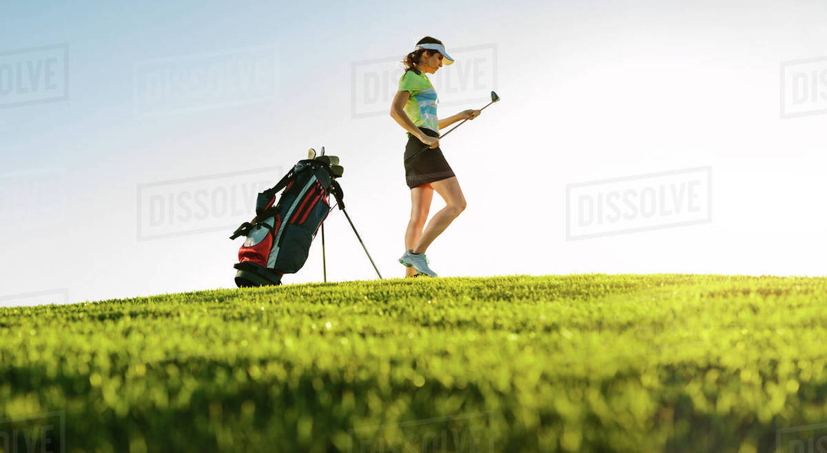 Low angle shot of professional female golfer on golf course. Full ...
