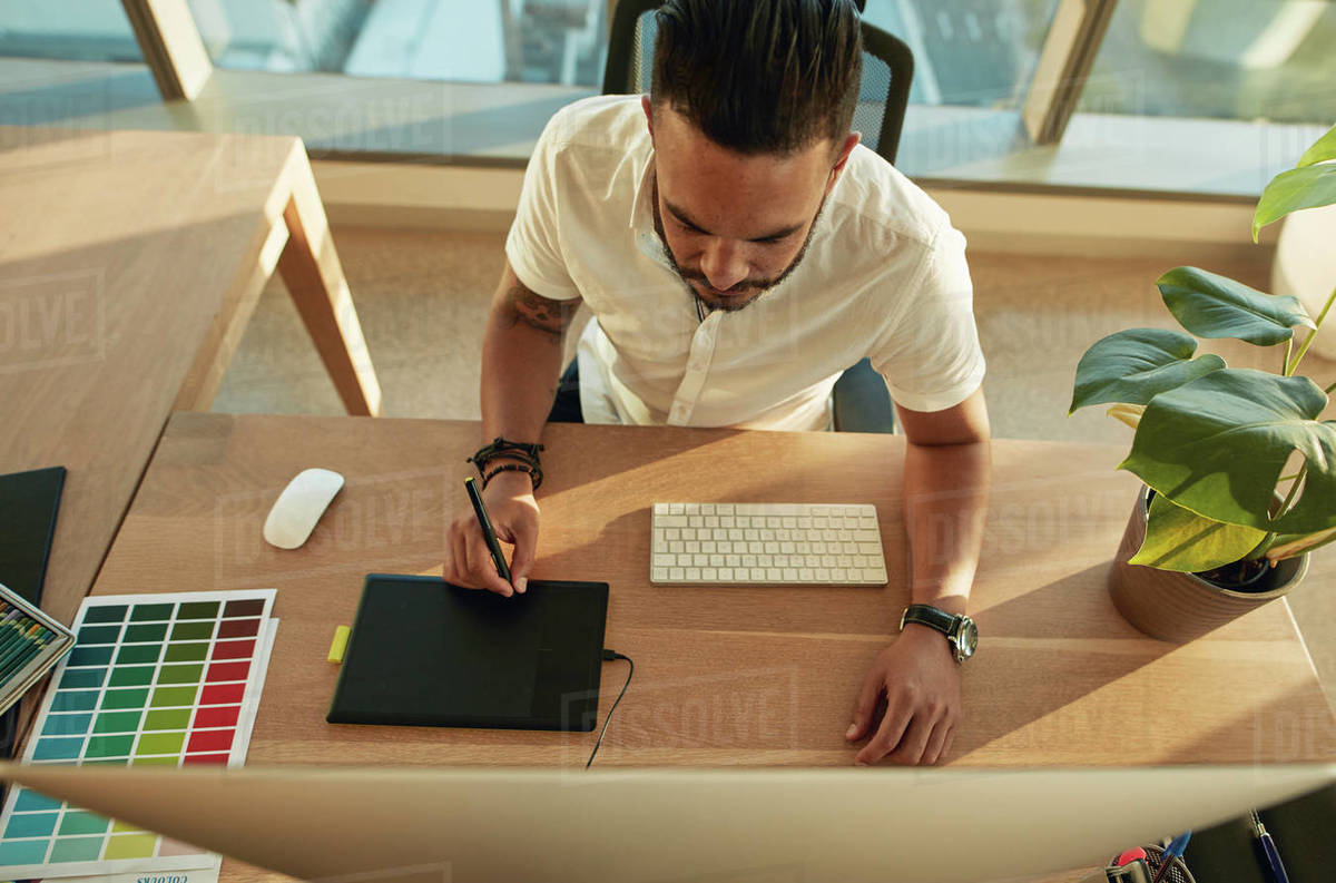 Top view shot of young man working in office using graphics tablet and ...