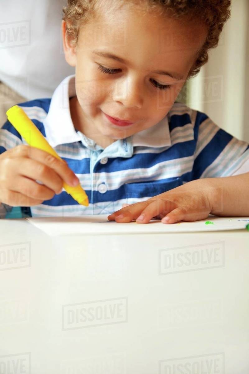 Young happy boy busy doing his art activity indoors - Royalty-free ...