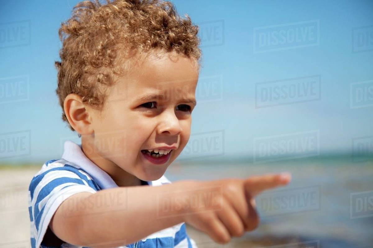 Adorable little kid pointing at something interesting outdoors ...