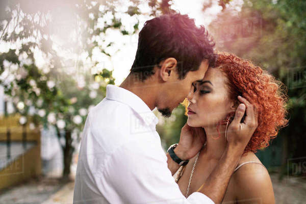 Close up of a young couple intimately close touching with heads about ...