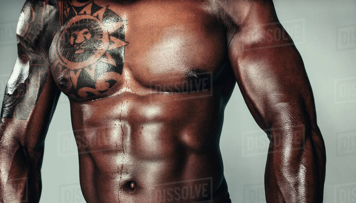 Close up shot of young african man with muscular body against grey ...