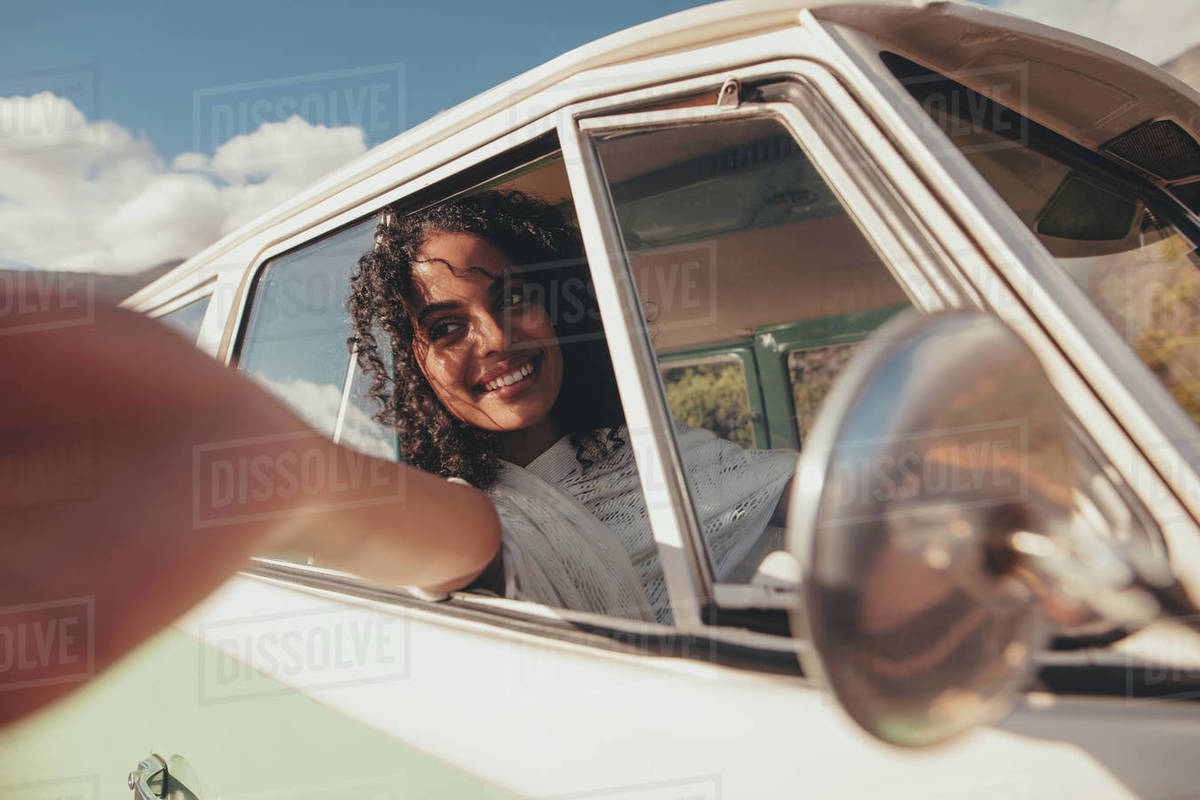 African woman road trip driving a van. Smiling young female driving a ...