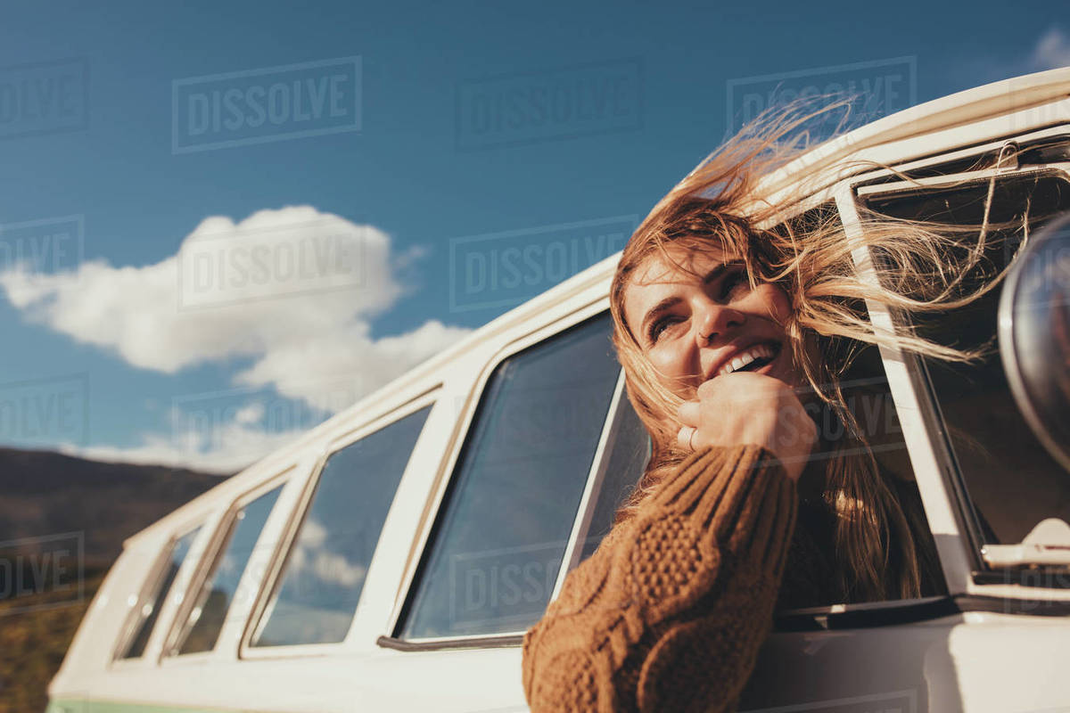 Woman driving a van and enjoying road trip. Laughing young female ...