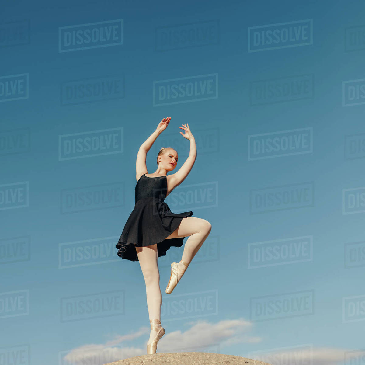 Ballet dancer practicing dance moves outdoors. Female dancer standing ...
