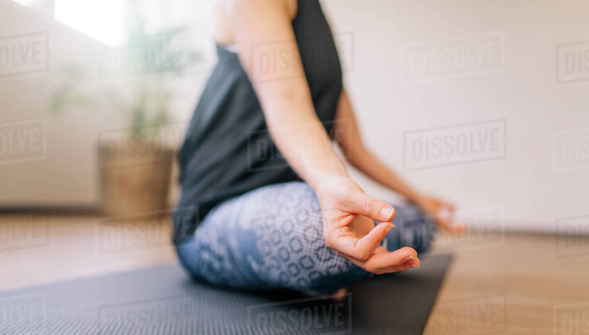 Close up of woman hand sitting in lotus pose indoors. Yoga and ...