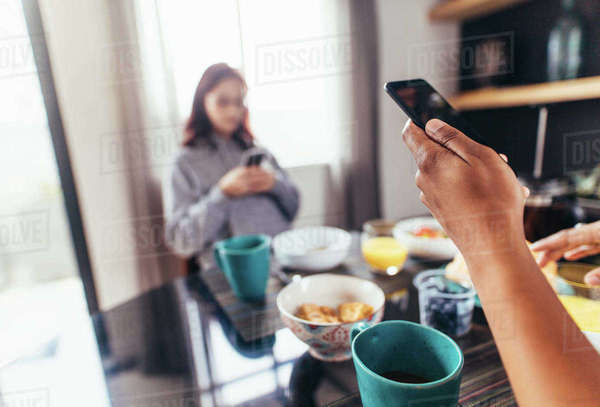Close up of man hand holding mobile phone while having breakfast with ...