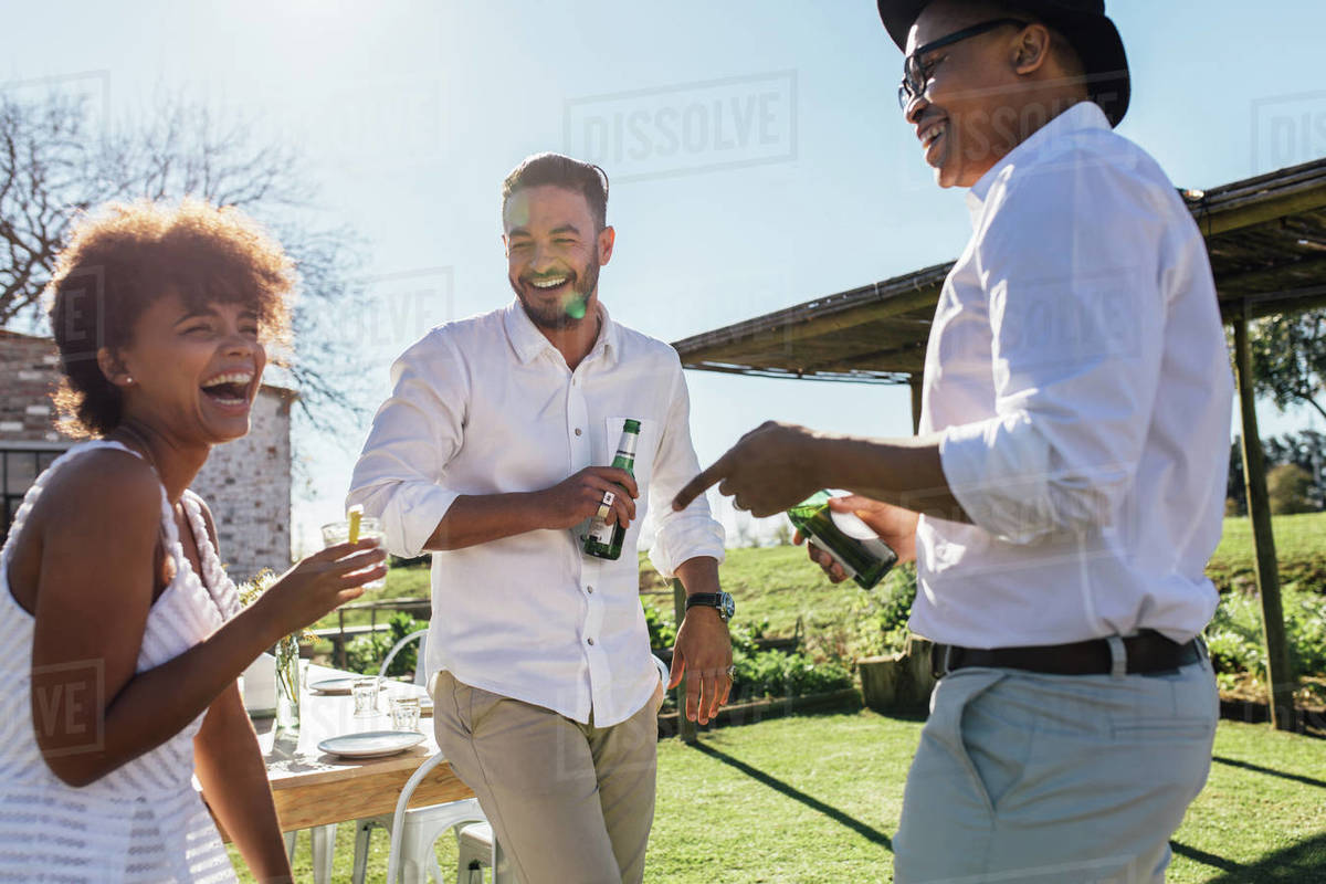 Laughing young people having a party at outdoor restaurant. Group of ...
