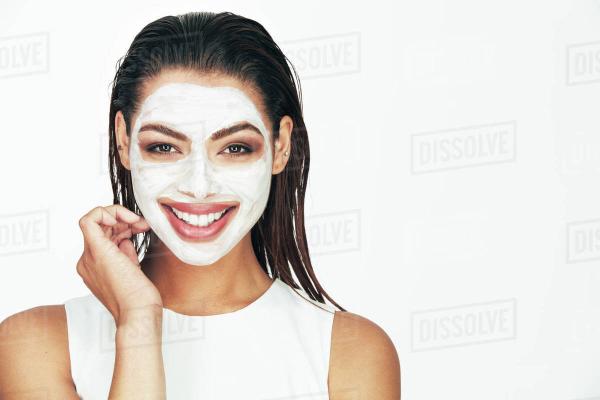 Close up of a smiling woman with cosmetic facial mask applied over her ...