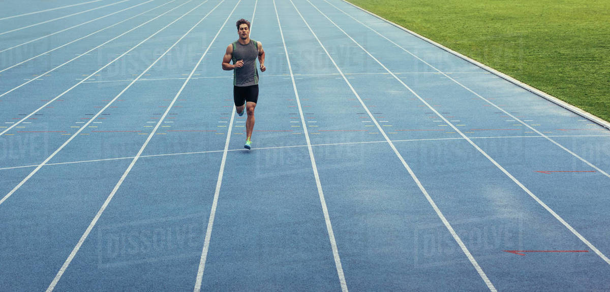 Athlete running on an all-weather running track alone. Runner sprinting ...
