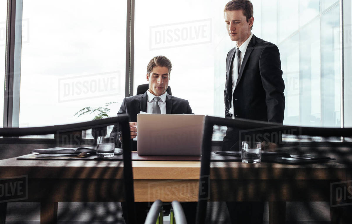 Business partners working together on laptop. Two corporate ...