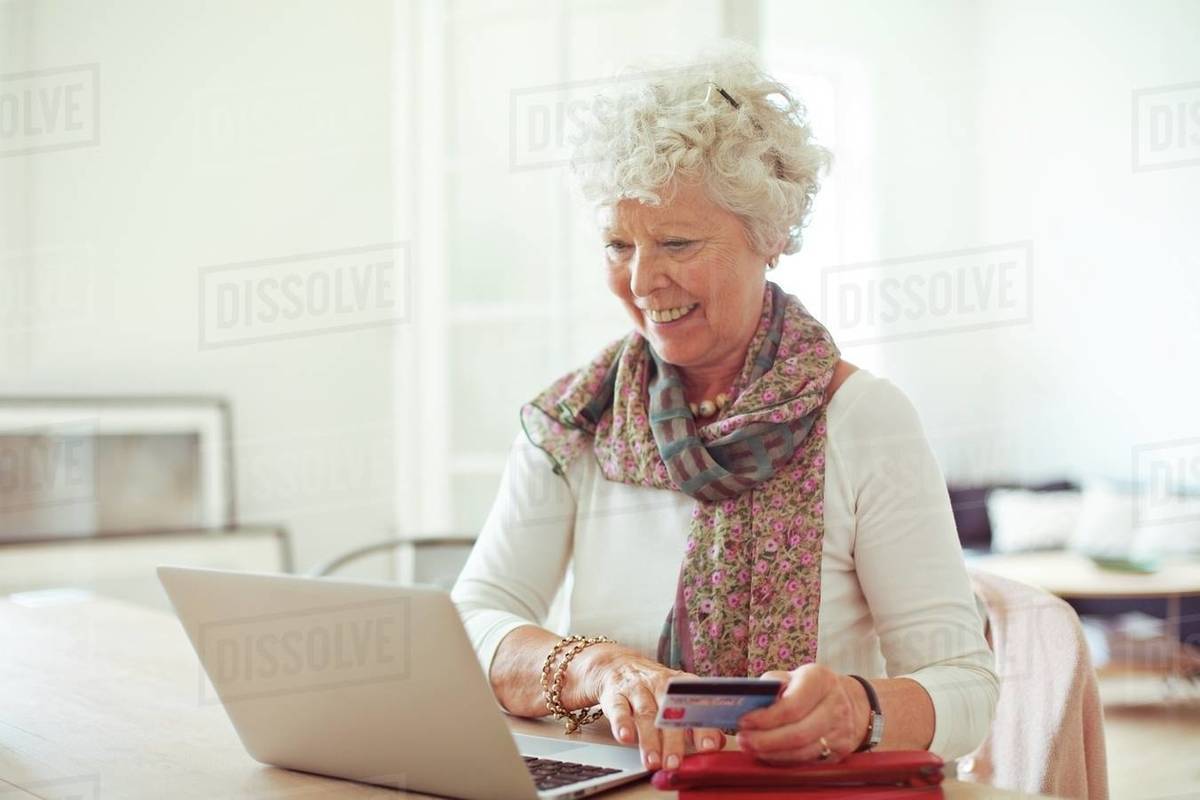 Happy old lady doing some shopping online using her laptop - Royalty ...