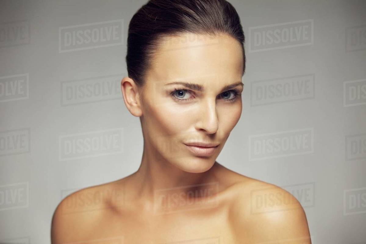 Closeup of a naturally beautiful woman with flawless skin looking at ...