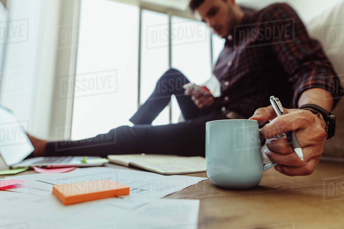Man working on laptop computer sitting on the floor at home. Freelancer ...