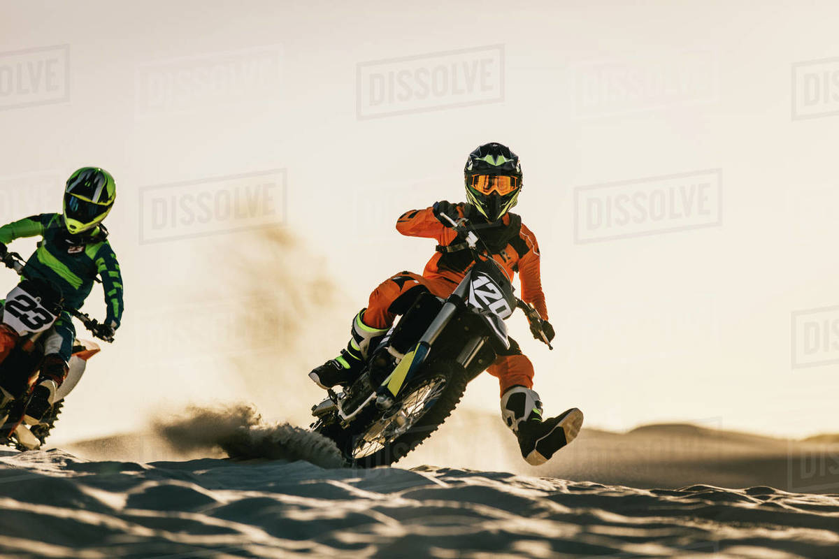 Motocross riders racing motorcycles in desert. Professional bike racers ...